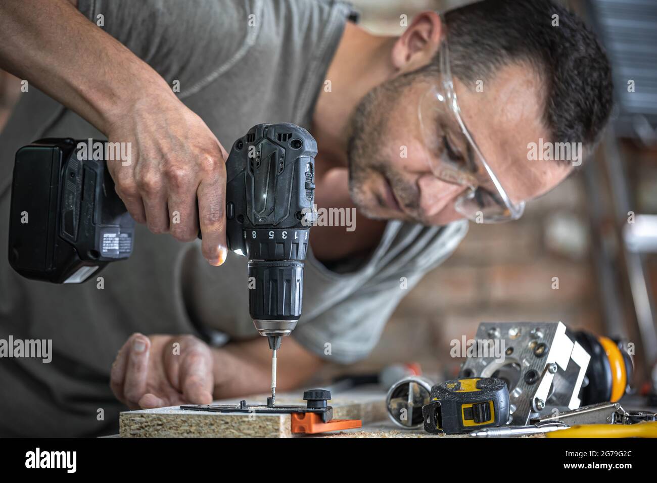 Screwing a self-tapping screw into a metal fastening hole on a wood ...