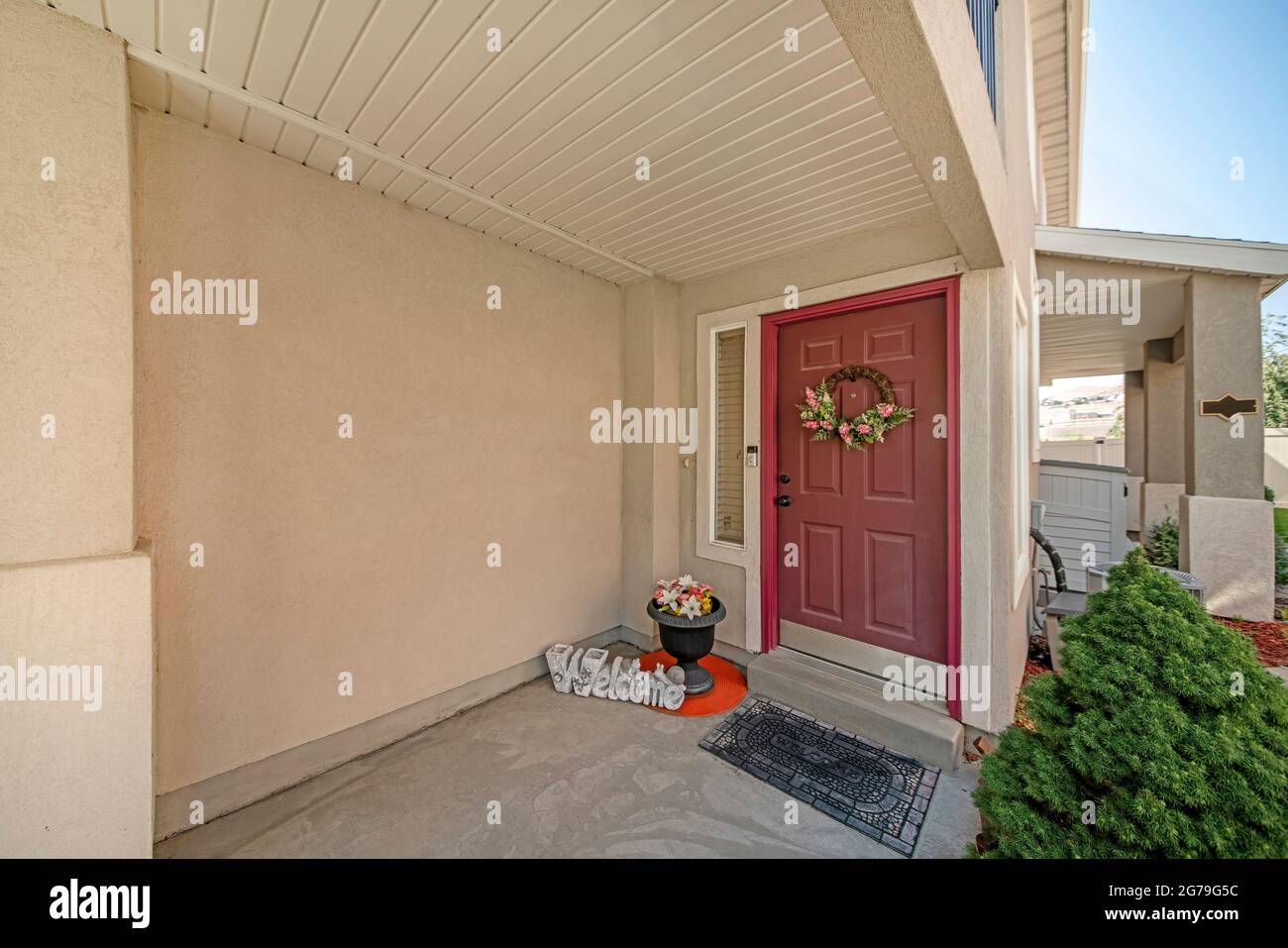 Front door exterior with decor and bush on the side Stock Photo - Alamy