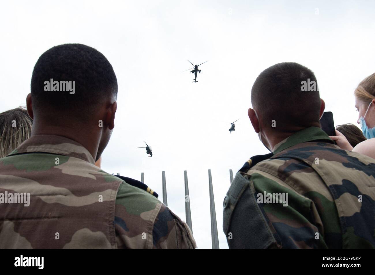 People look at French military Helicopters fly over Paris, during a ...