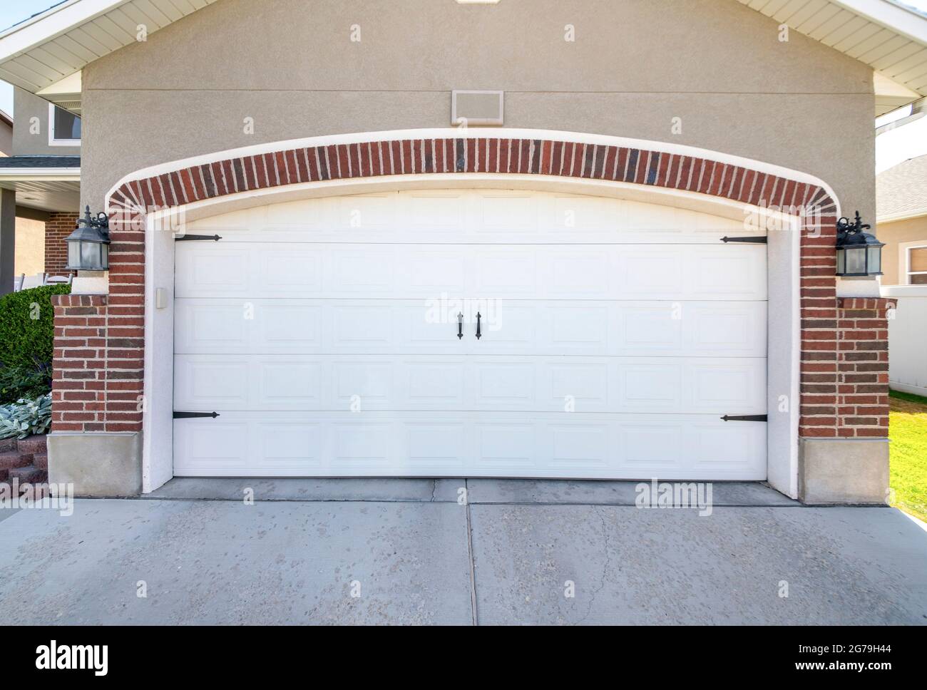 Closed carriage style white garage door of a house with bricks Stock ...