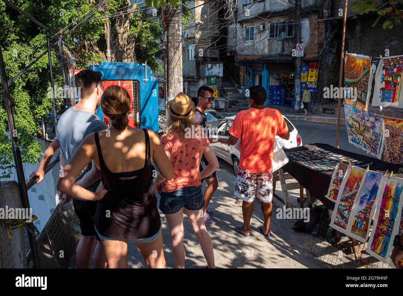 A street view looking down a road with scooters & graffiti on the wall ...