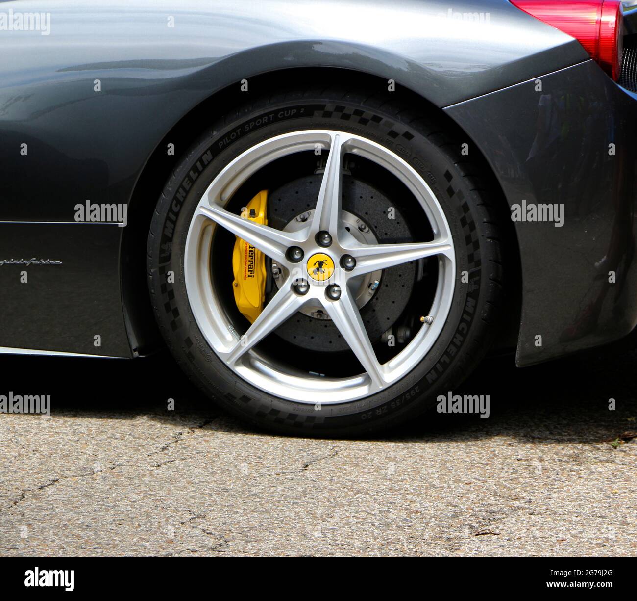 Close up of the rear wheel of a grey Ferrari 458 Italia car parked at a ...
