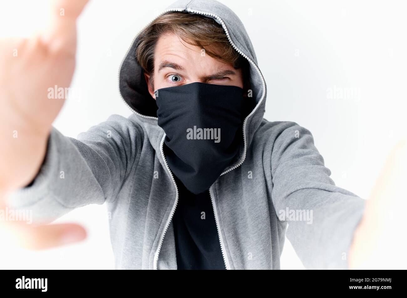 a man in a hood hides his face in a mask bully anonymity Stock Photo ...