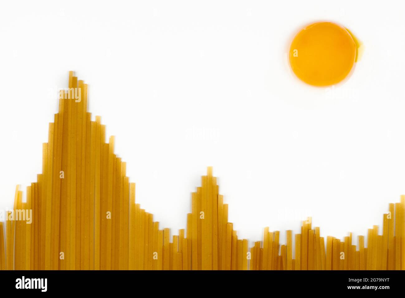 Sun in mountains. Uncooked spaghetti in shape of hills and egg as sun ...