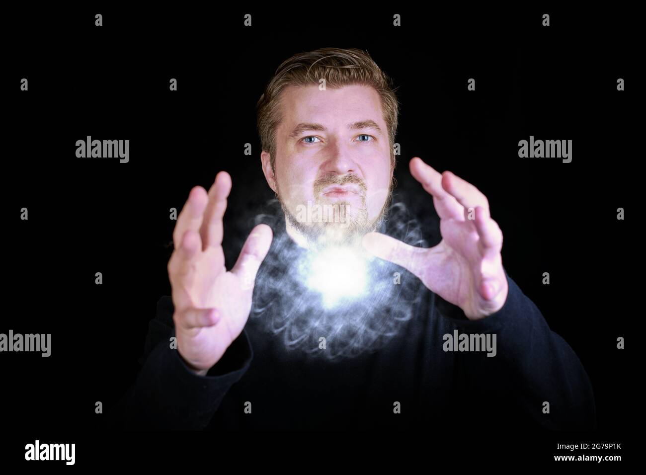 Energy ball in wizard hand. Bearded man casting bright magic ball spell ...