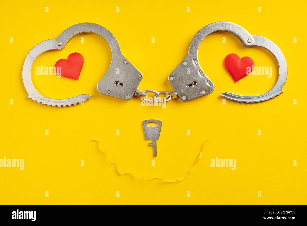 Handcuffs smile shape on yellow background. Freedom concept ...