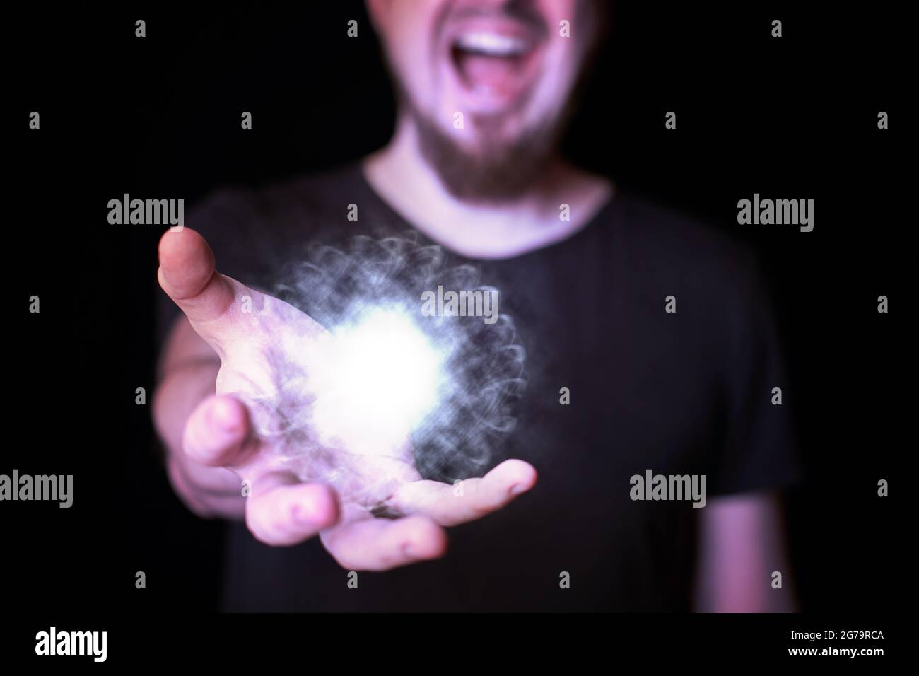 Energy ball in wizard hand. Bearded man casting bright magic ball spell ...