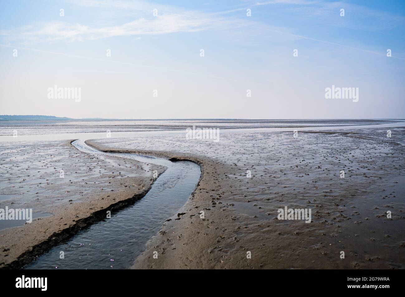 Small river floating through the mudflat of the north sea at sahlenburg ...