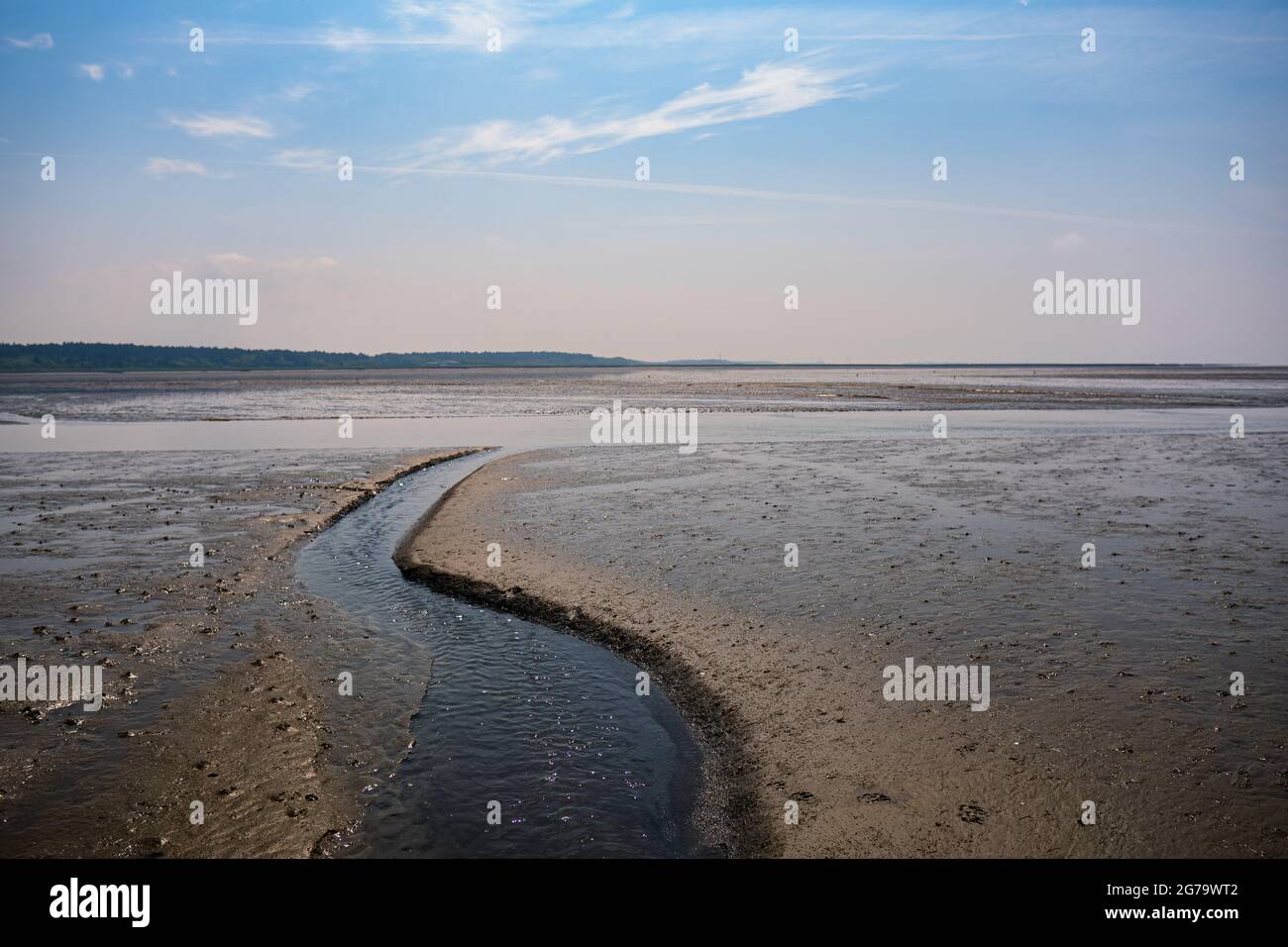 Small river floating through the mudflat of the north sea at sahlenburg ...