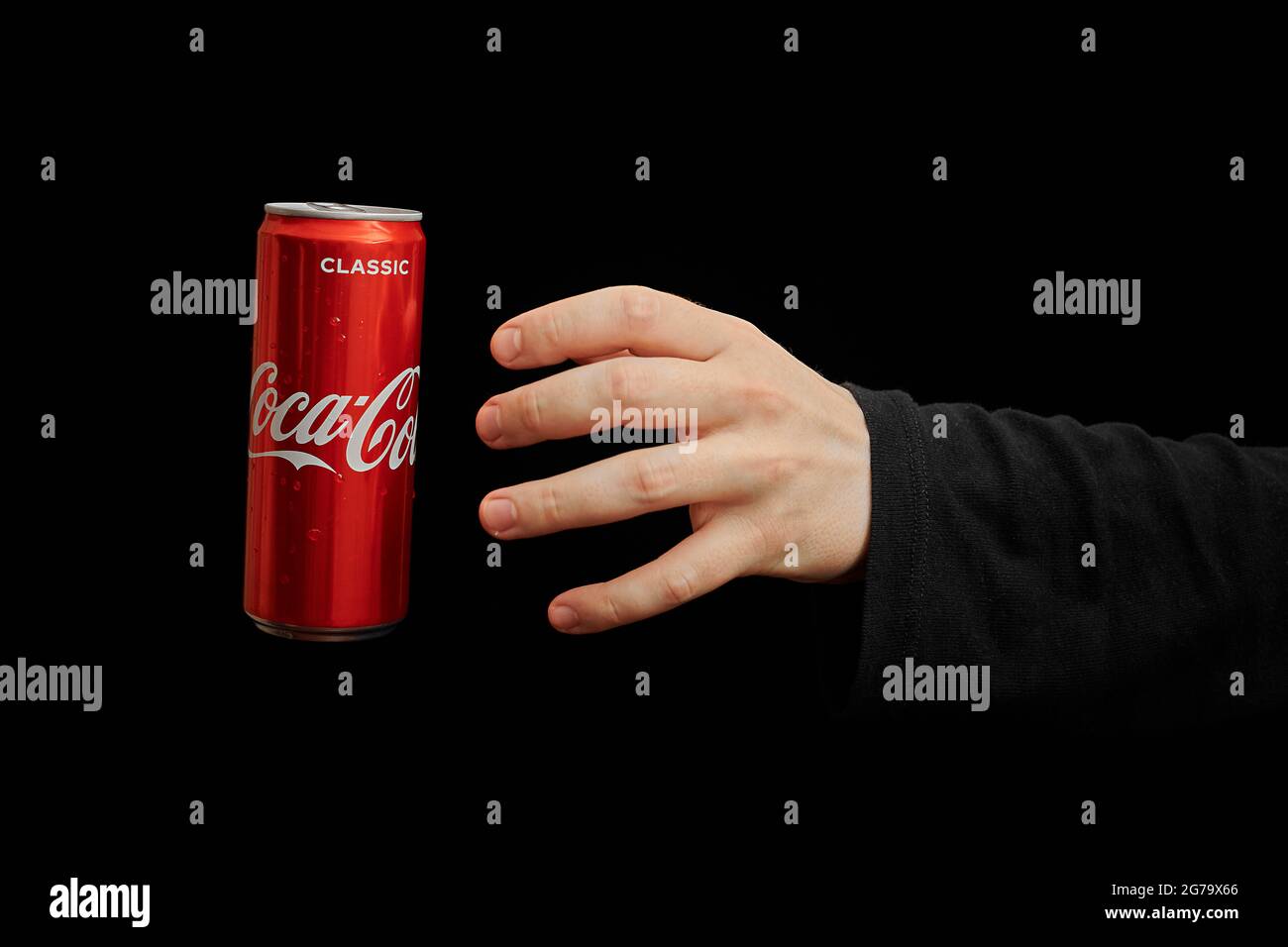 KALININGRAD, RUSSIA - MARCH 13, 2021 - Hand reaches to Coca Cola can ...