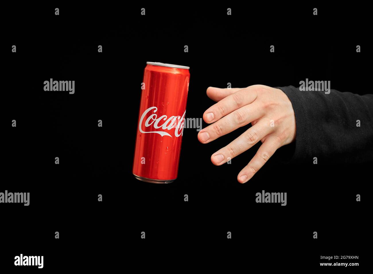 KALININGRAD, RUSSIA - MARCH 13, 2021 - Hand reaches to Coca Cola can ...