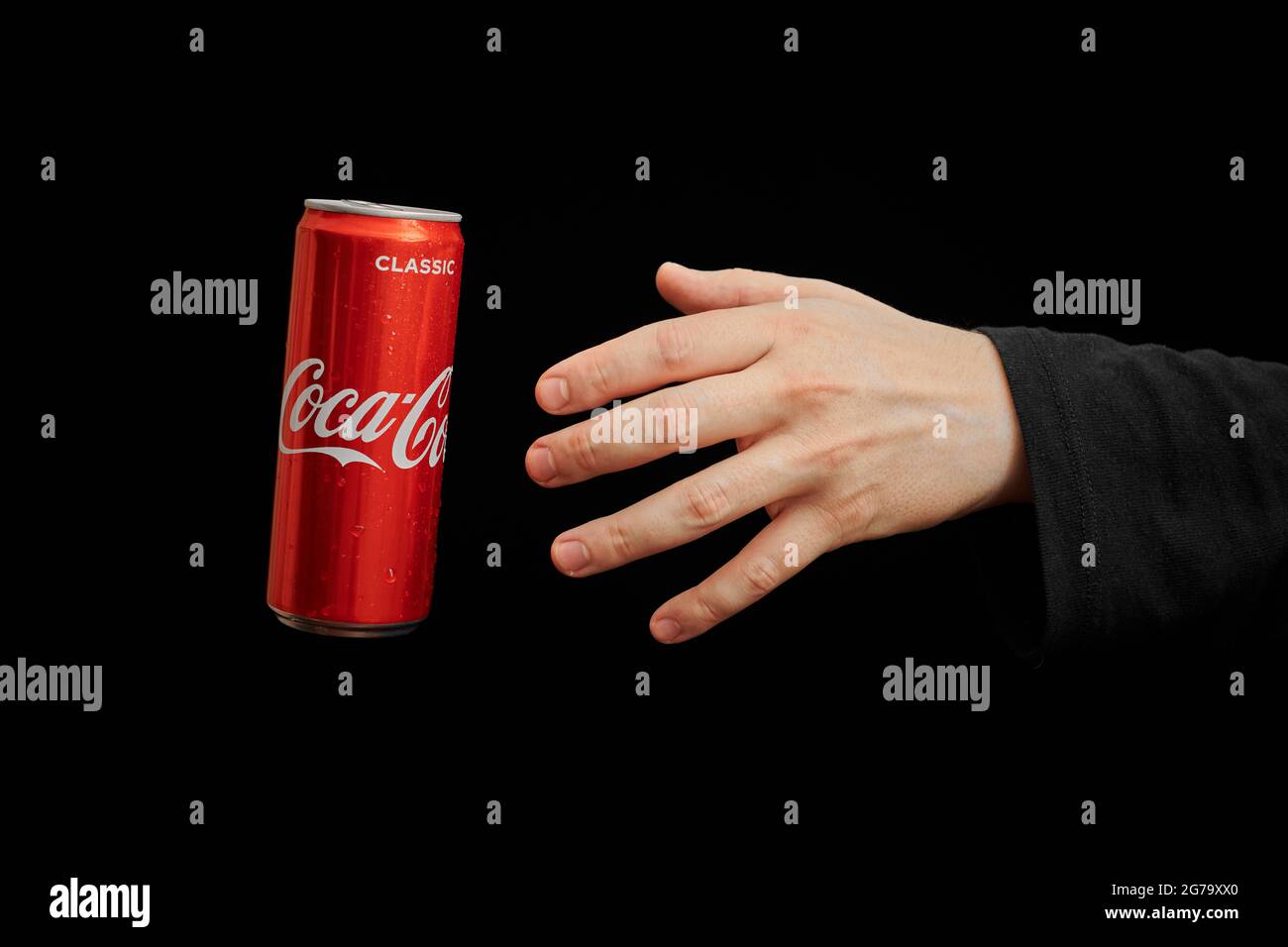 KALININGRAD, RUSSIA - MARCH 13, 2021 - Hand reaches to Coca Cola can ...