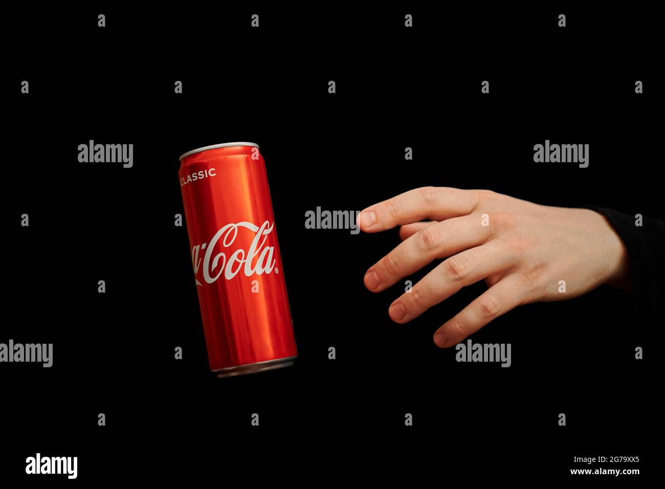 KALININGRAD, RUSSIA - MARCH 13, 2021 - Hand reaches to Coca Cola can ...