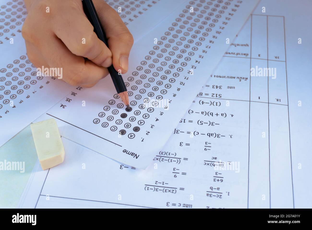Students hand holding pencil writing selected choice on answer sheets ...