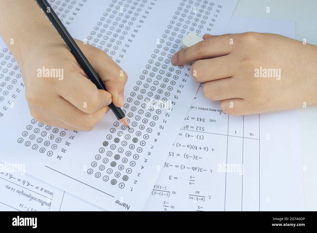 Students hand holding pencil writing selected choice on answer sheets ...