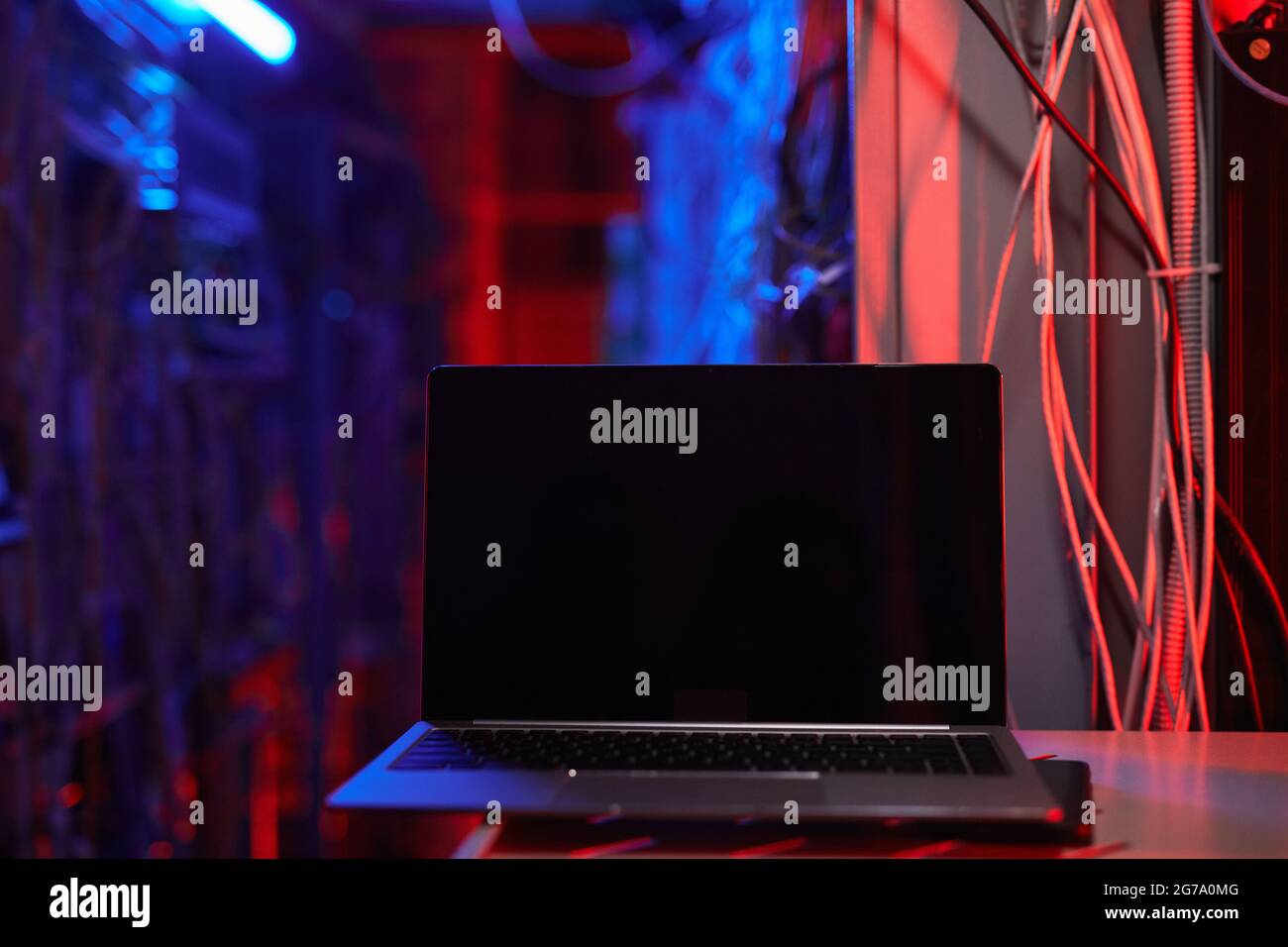 Background image of blank laprop screen in dark server room, copy space ...