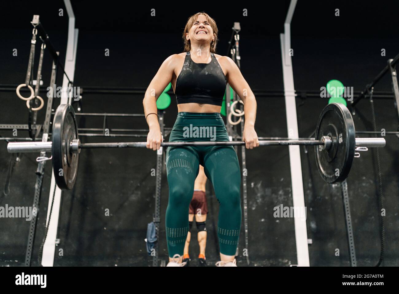 Woman performing a weightlifting exercise inside a gym Stock Photo - Alamy