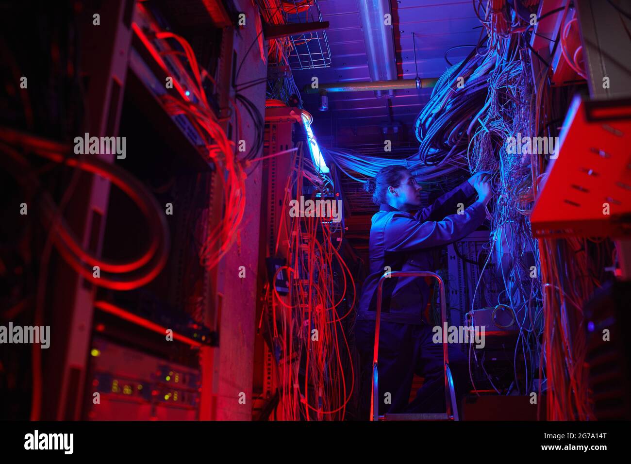 Wide angle portrait of young man setting up computer network in server ...