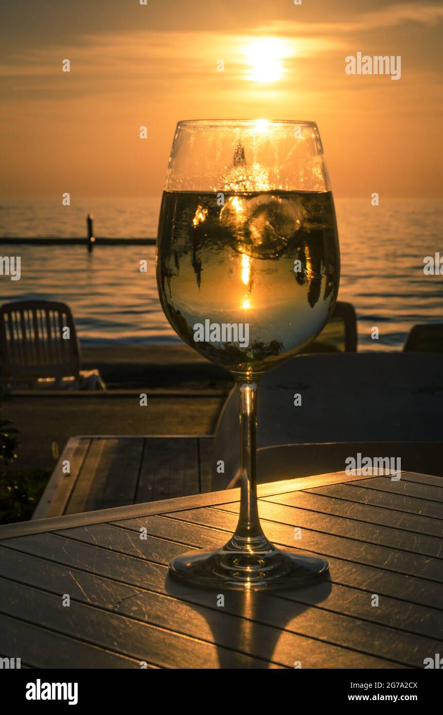 glass of wine on the table and sunset over sea horizon Stock Photo - Alamy