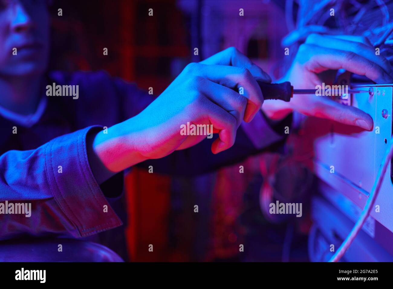 Close up of man setting up computer network in server room with cables ...