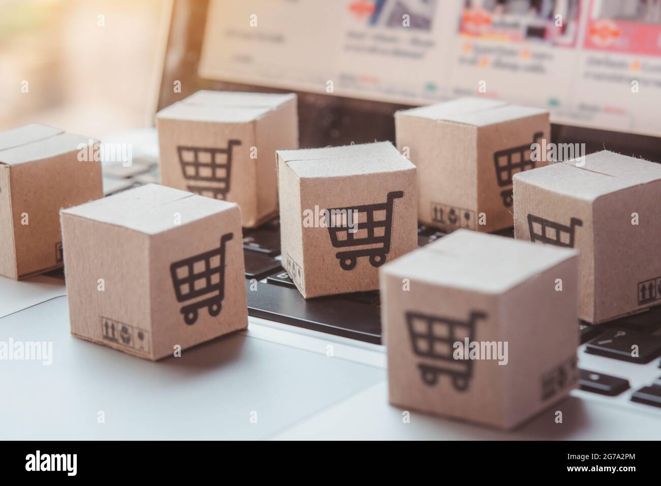 Shopping online. Cardboard box with a shopping cart logo on laptop ...