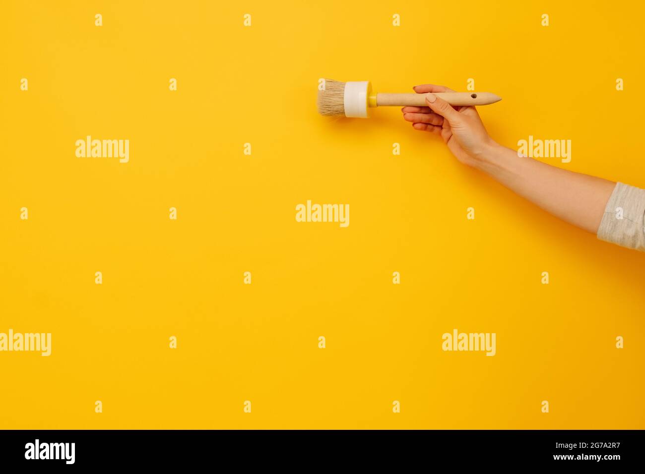 Hand holding paint brush Stock Photo - Alamy