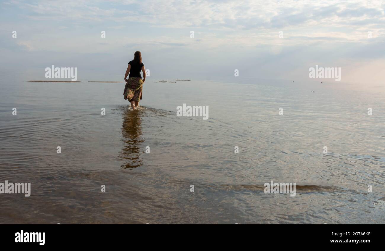 Woman wading into water hi-res stock photography and images - Alamy