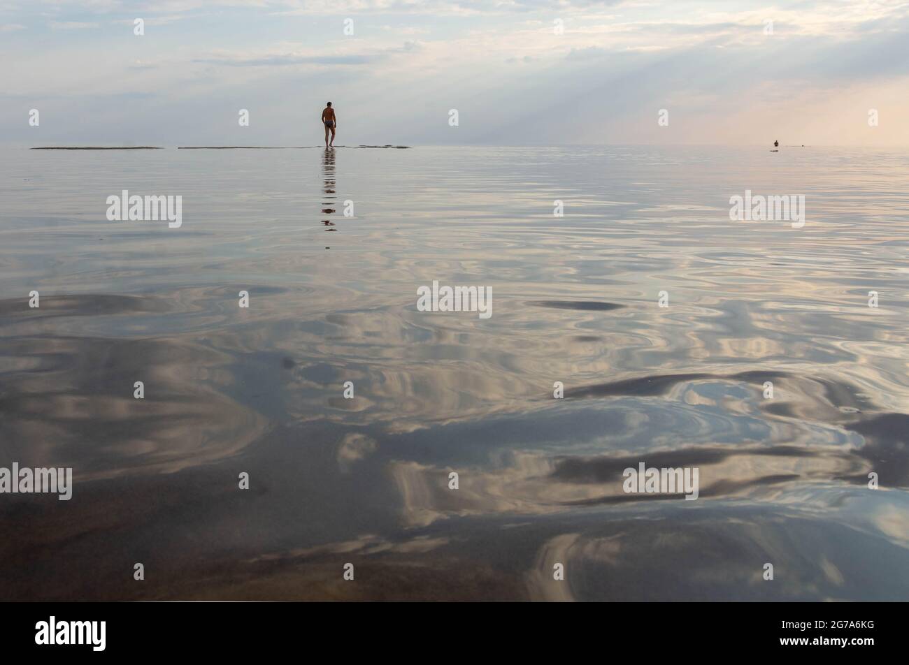woman wading in water on a calm evening Stock Photo - Alamy