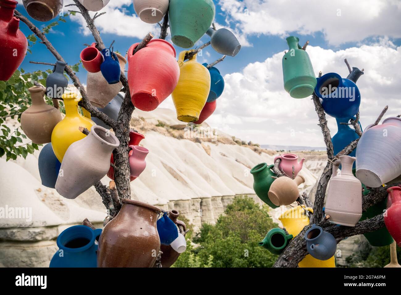 Colorful vases hanging on tree branch Stock Photo - Alamy