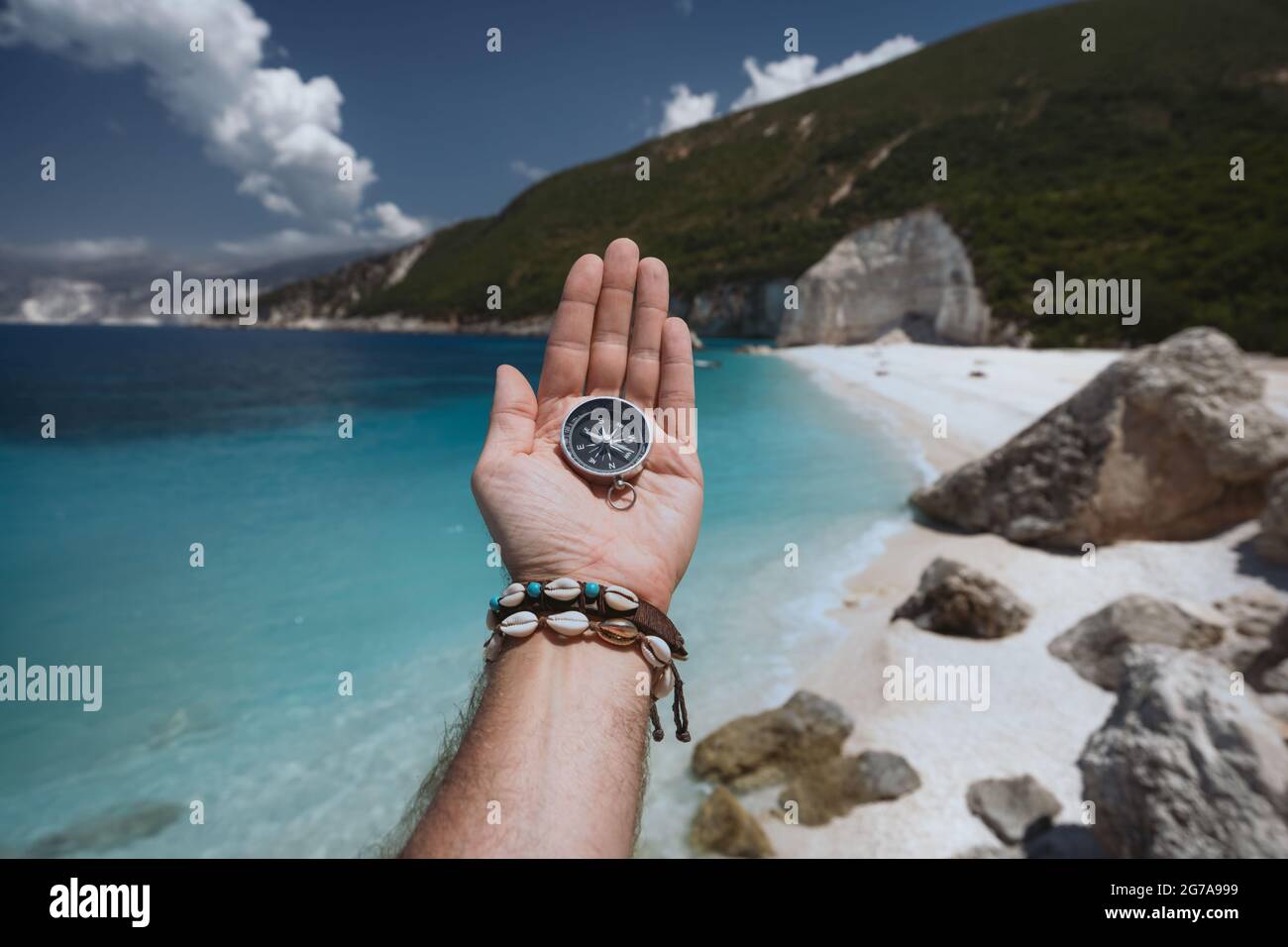 Hand holding a compass on the beach in background Stock Photo - Alamy