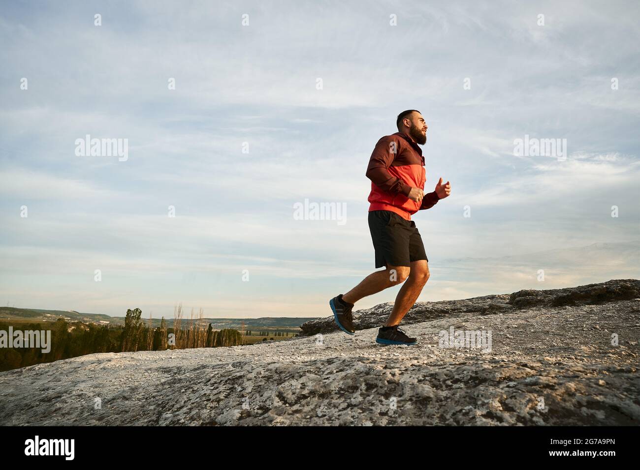 Young muscular male athlete running up the hill Stock Photo - Alamy