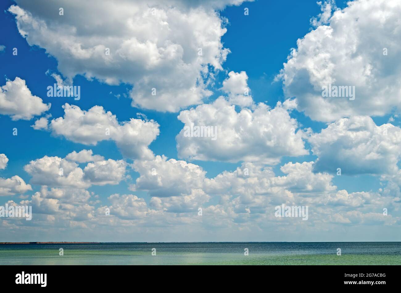 Cumulus clouds on warm summer day over shallow sea coast Stock Photo ...