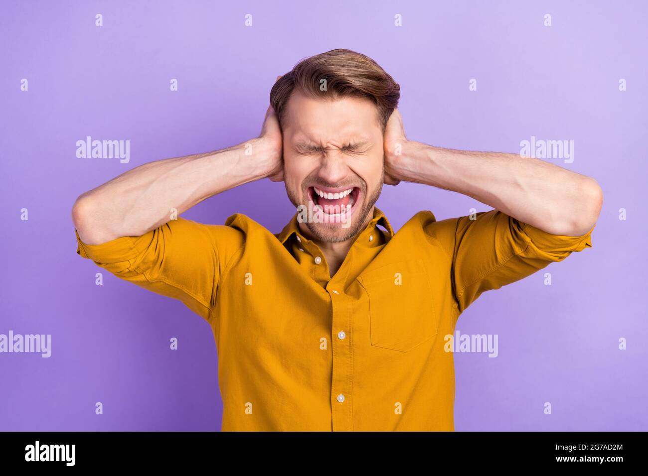 Portrait of attractive crazy desperate guy closing ears yelling ...