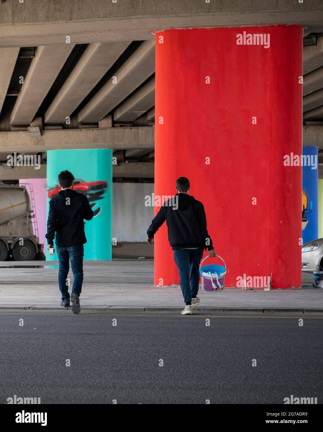 Back rear view of wall painters walking with paint buckets Stock Photo ...