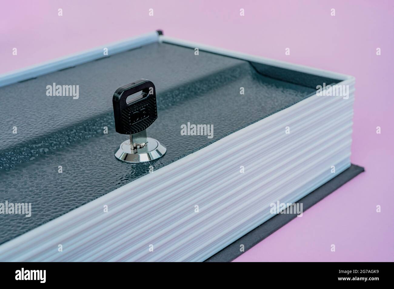 Big black and white book piggy bank with key on violet isolated ...