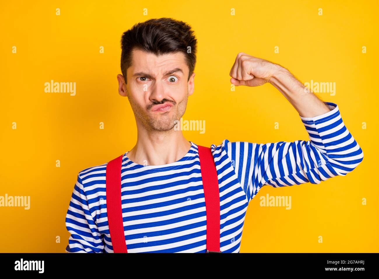 Photo of young handsome serious funky funny man sailor showing muscles ...
