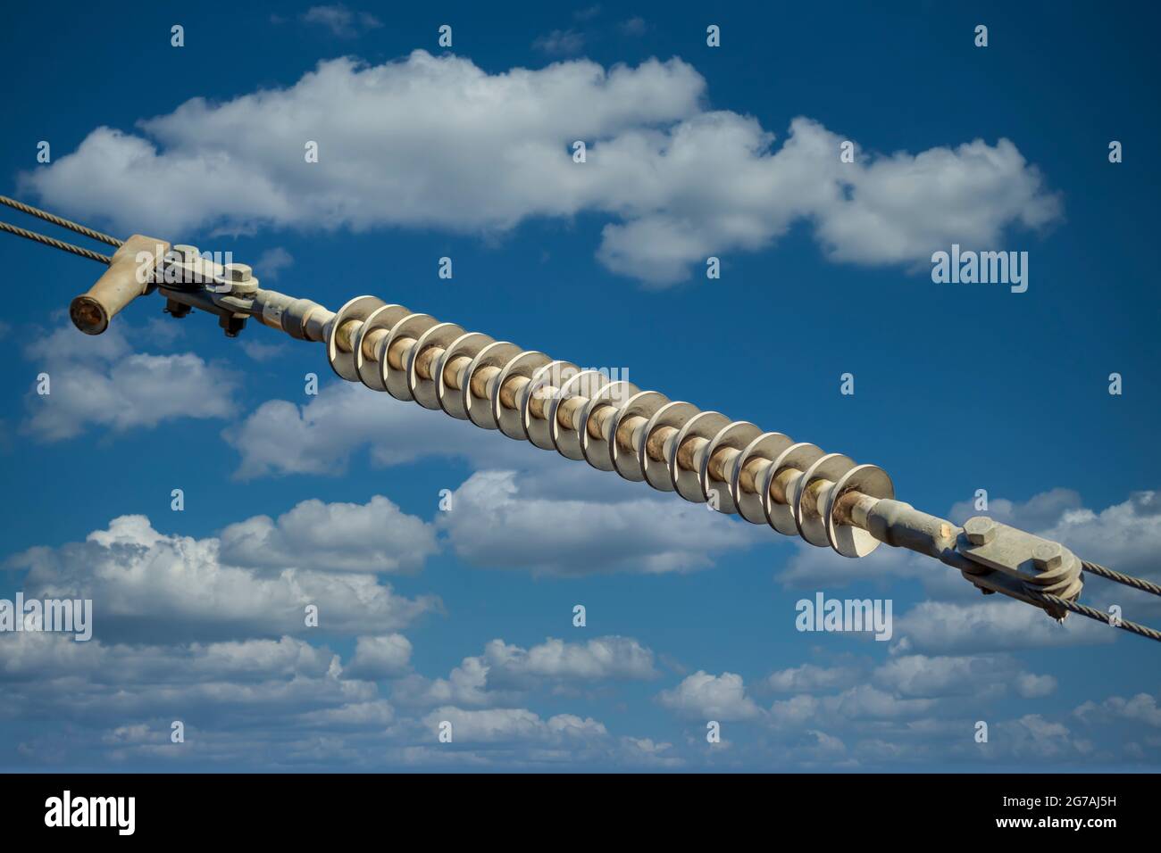 Photograph of a tensioner bracket on a transmission line against a ...