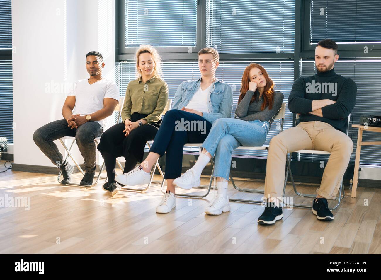 Group of tired five young diverse multiethnic men and women waiting job ...