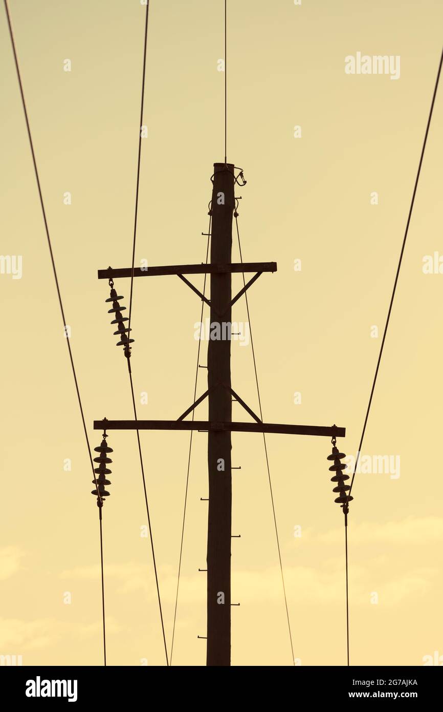Photograph of a wooden telephone post and cables against a blue sky ...