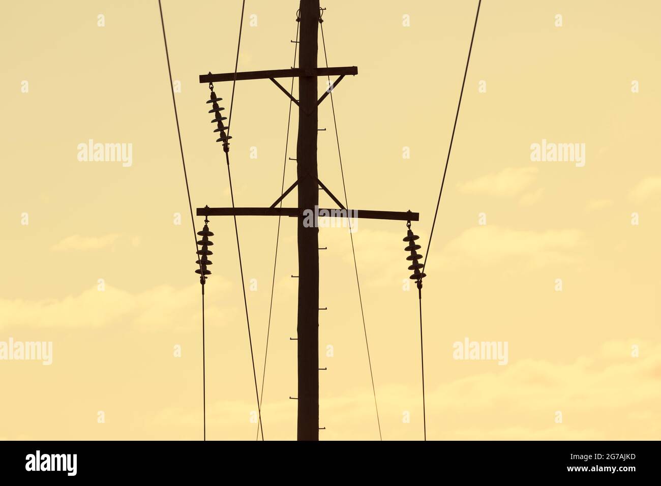 Photograph of a wooden telephone post and cables against a blue sky ...