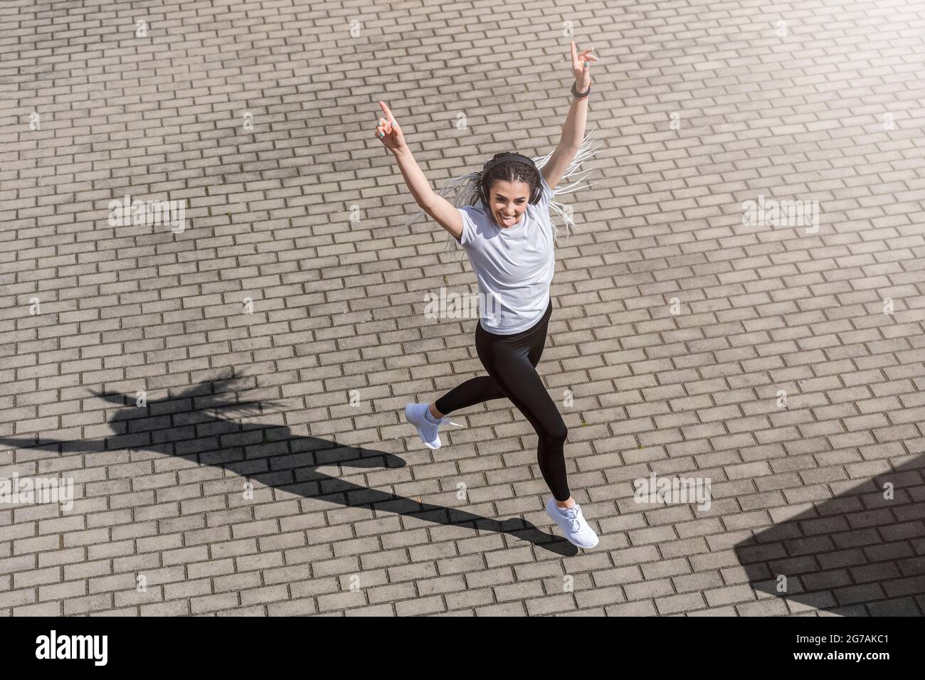 Woman listening music running in city street. Sport activities on ...