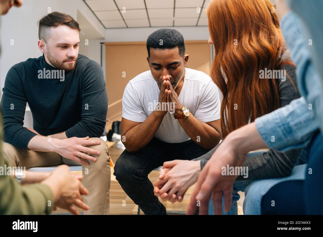 Front view of depressed African American young man sharing problem ...
