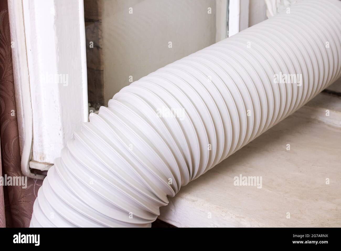 Corrugated pipe from the air conditioner on the windowsill close up ...