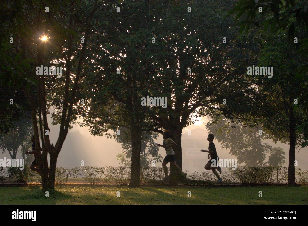 Young women badminton players are running circle a park during a ...