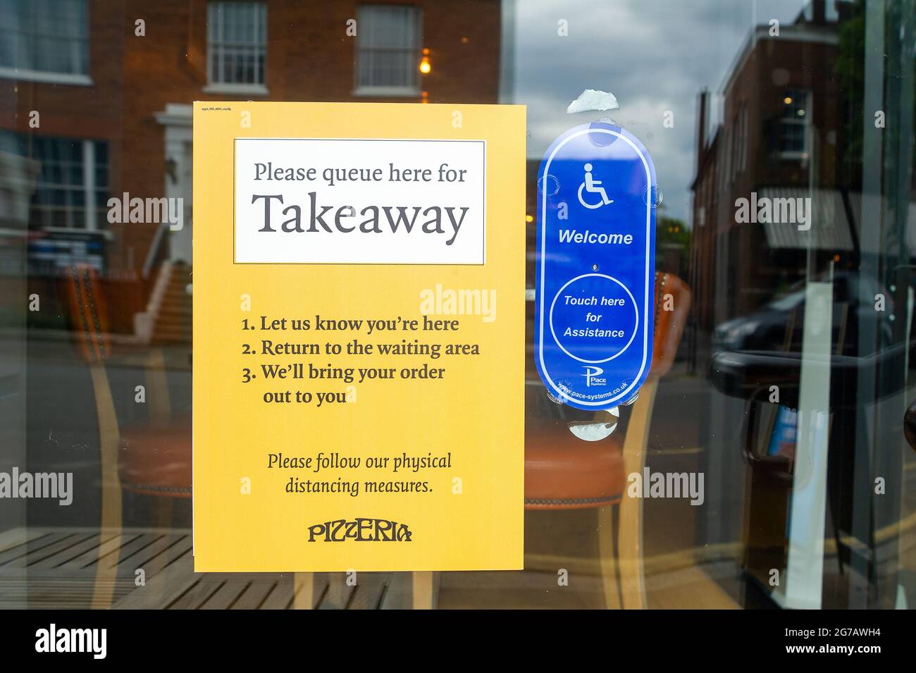 Wokingham, Berkshire, UK. 12th July, 2021. A queue here sign at Pizza ...