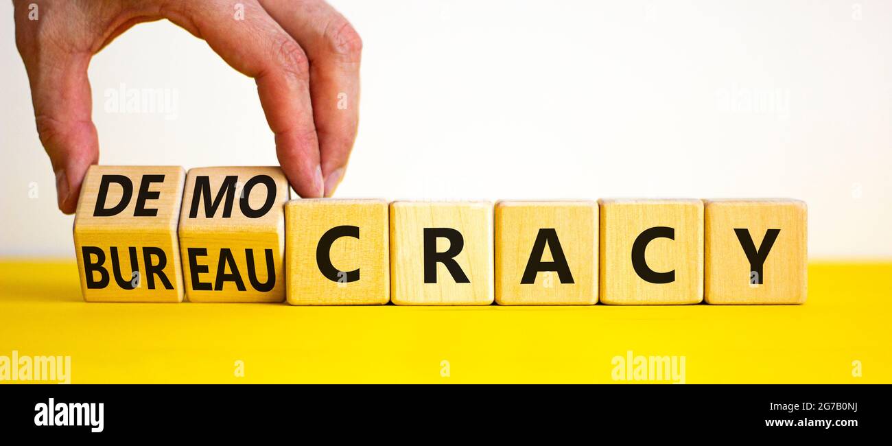Democracy or bureaucracy symbol. Businessman turns wooden cubes and ...