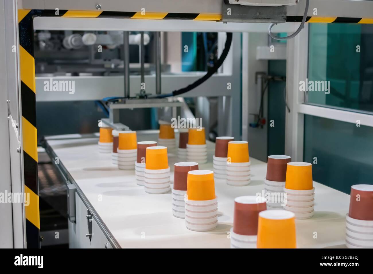 Empty plastic cups moving on conveyor belt at package exhibition Stock ...