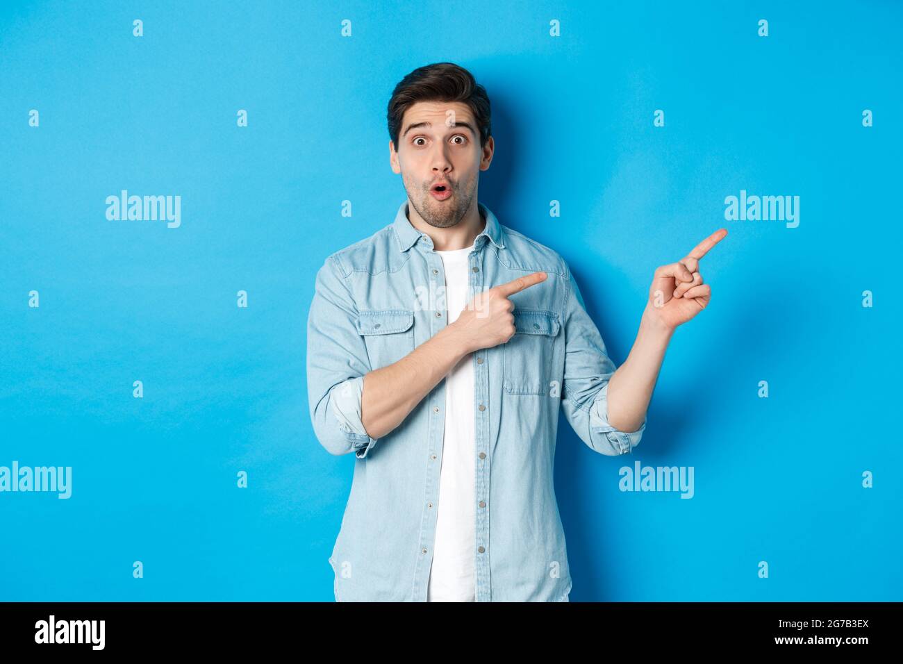 Portrait of surprised bearded guy in casual outfit pointing fingers ...