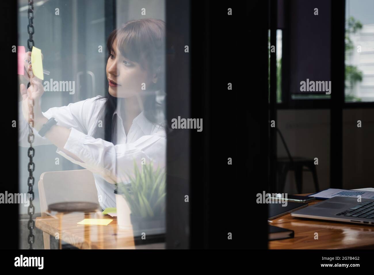 Woman writing on post it note hi-res stock photography and images - Alamy