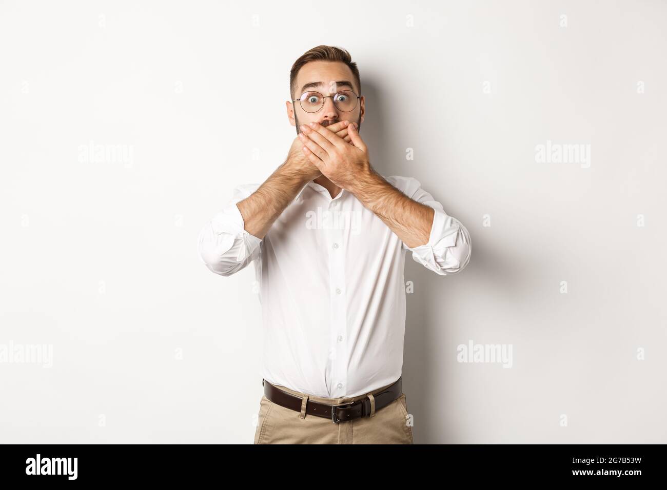 Shocked man gasping and looking at something in awe, covering mouth ...